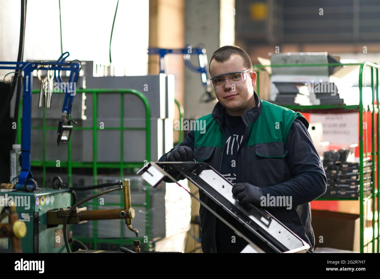 a uniformed worker working in a modern metal production and processing ...