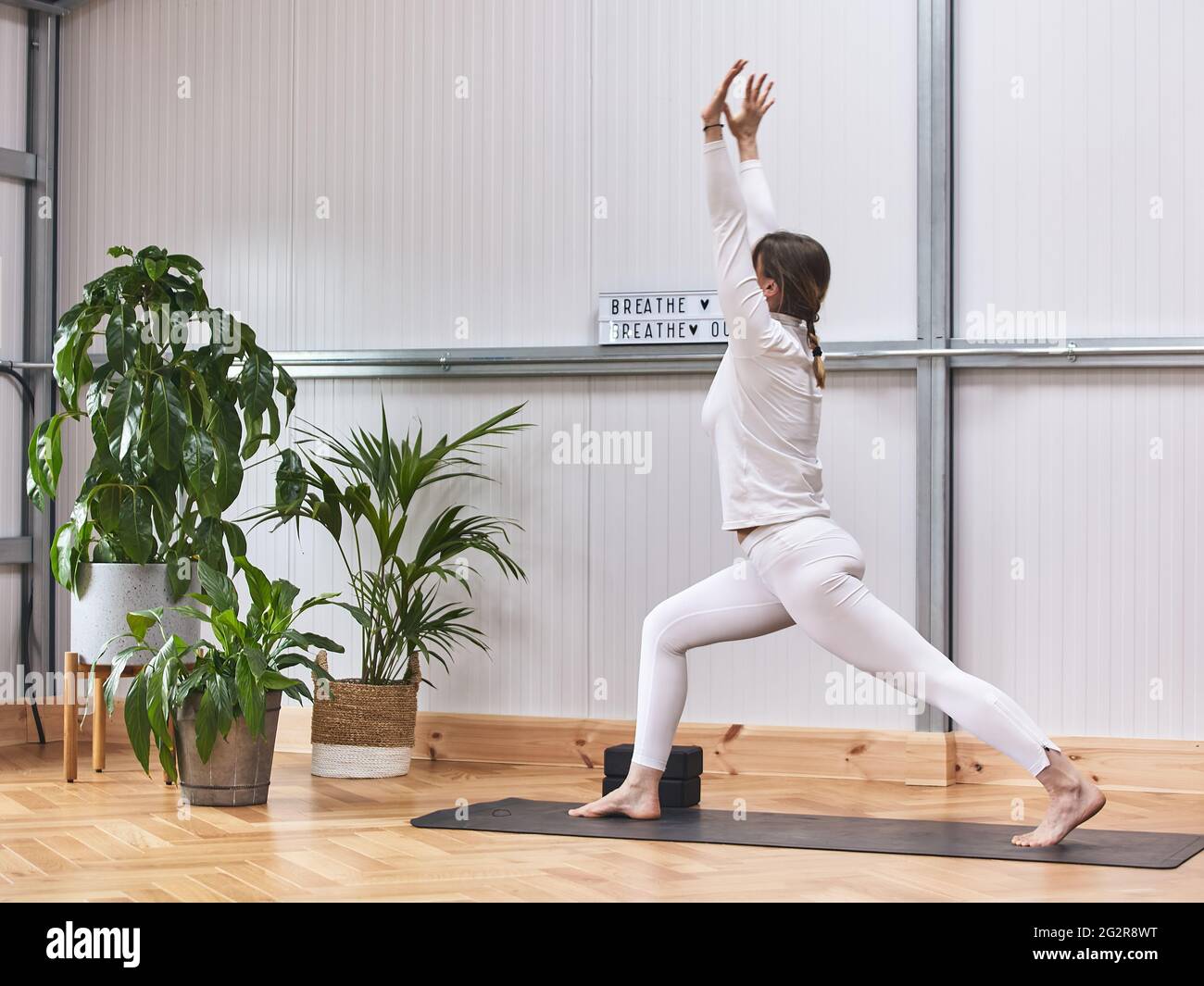 Slender russian girl standing in yoga asana on mat Peaceful focused ...