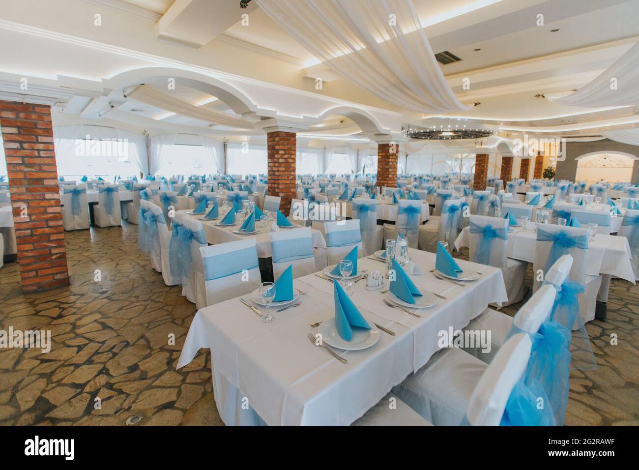 Empty restaurant with tables covered by white and blue tableware ready ...