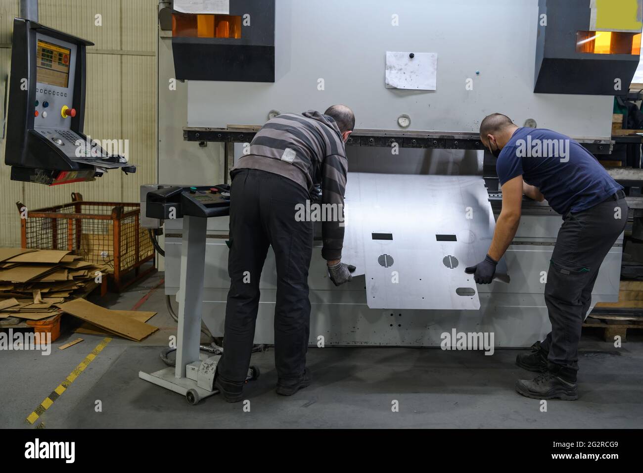 a two man working in a modern industry prepares material for processing ...
