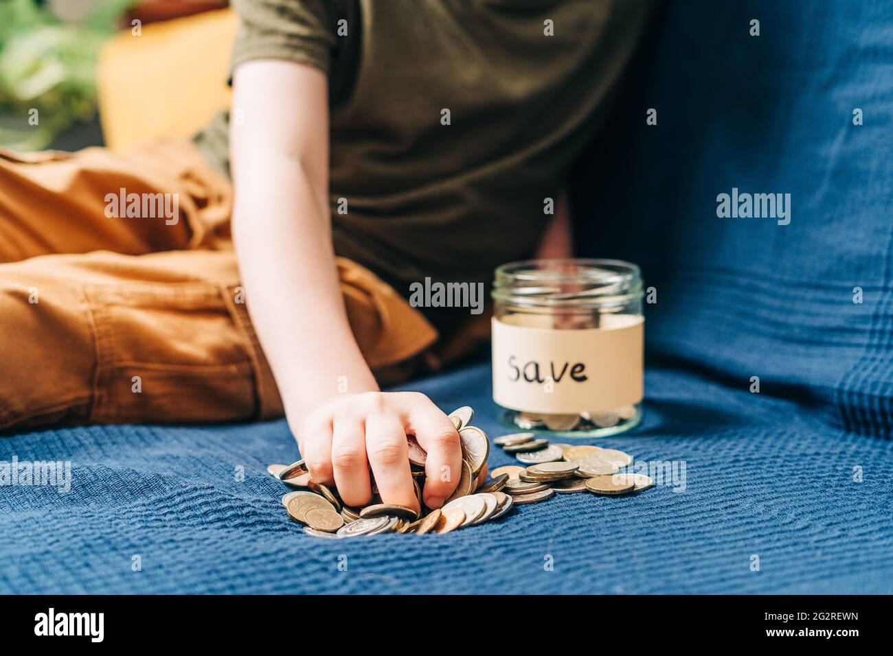 Close up of Little child kid boy hands grabbing and putting stack coins ...
