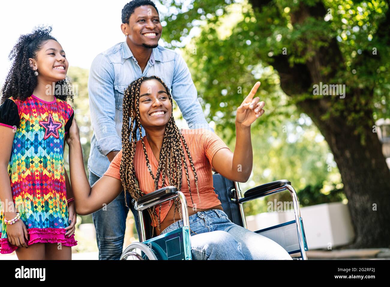 Woman in a wheelchair enjoying a walk outdoors with family Stock Photo ...