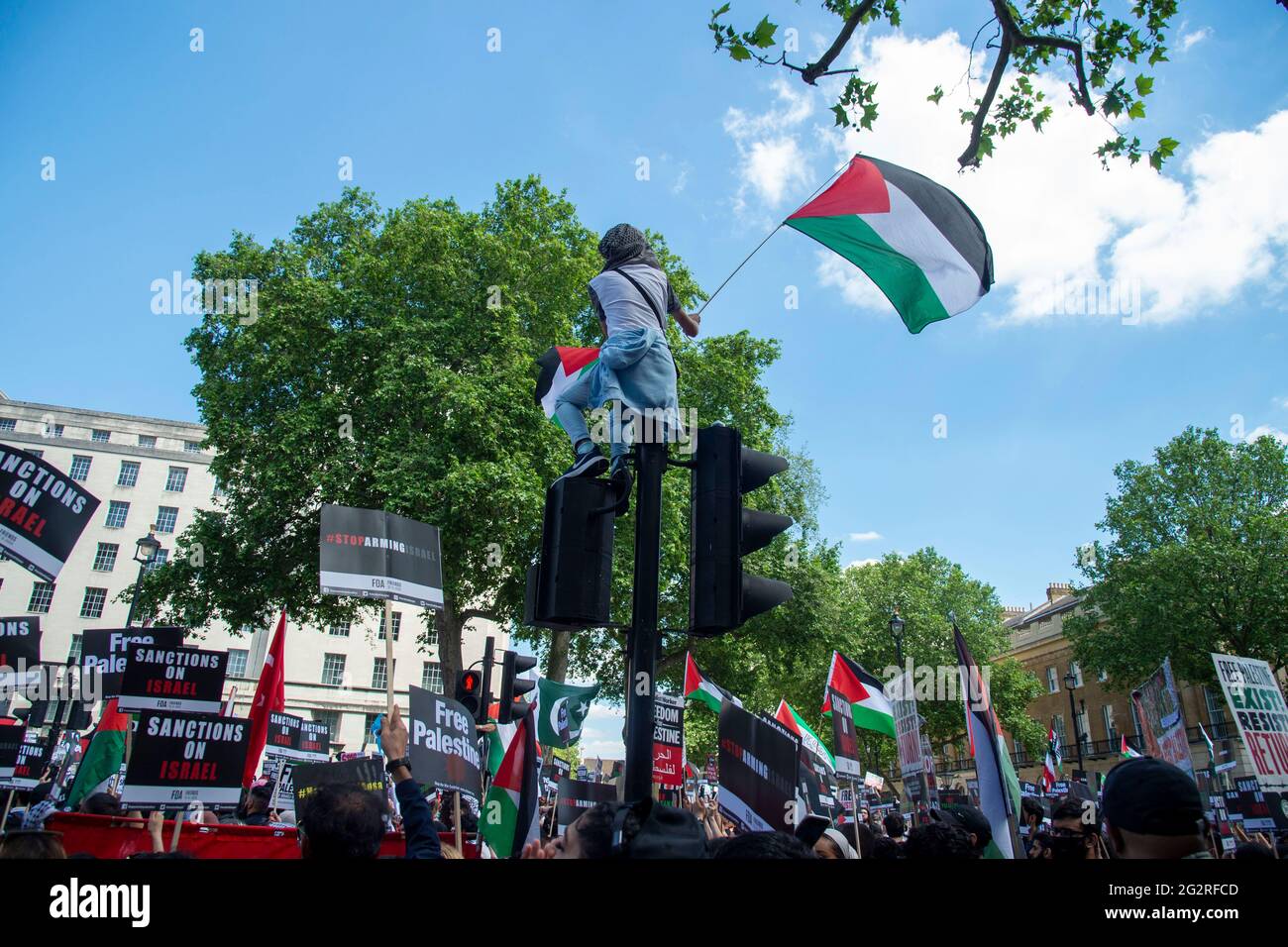 A protester sits on top of the traffic lights outside the gates of ...