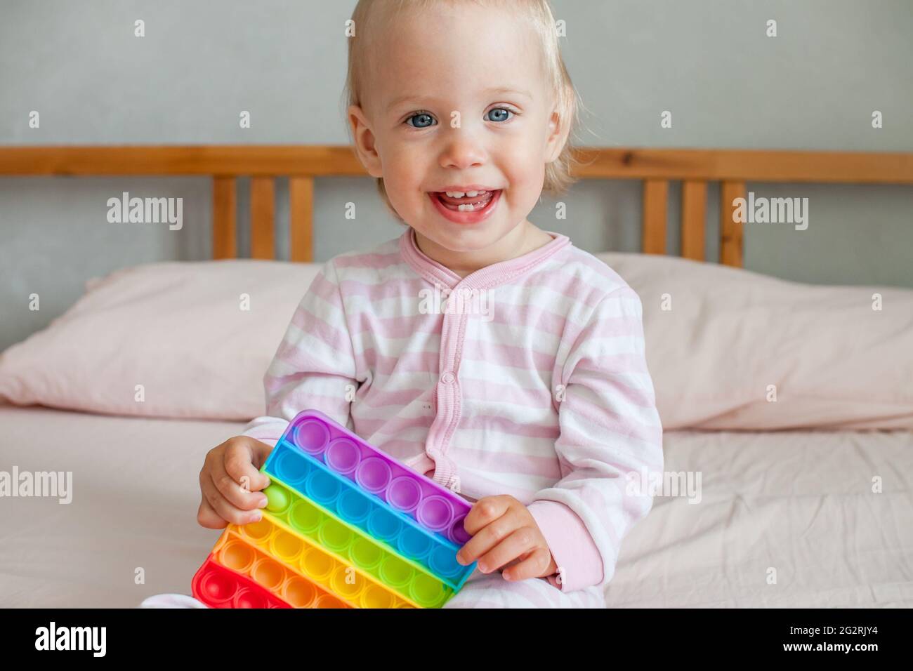 Little girl plays with trendy sensory toy pop it. The girl presses on ... Little girl plays with trendy sensory toy pop it. The girl presses on ...