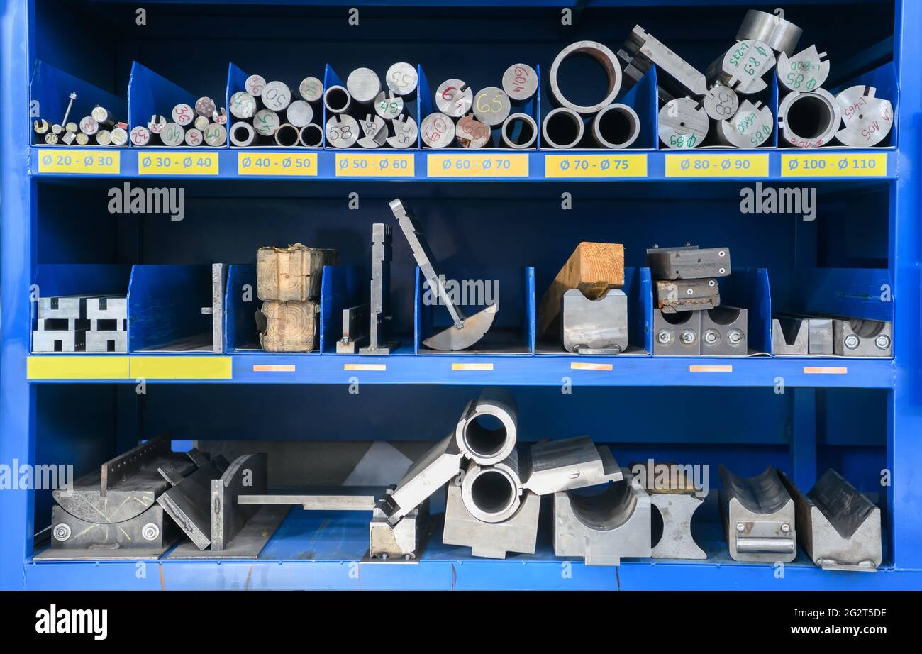 pipes, metal pieces and various metal parts for a CNC machine standing ...