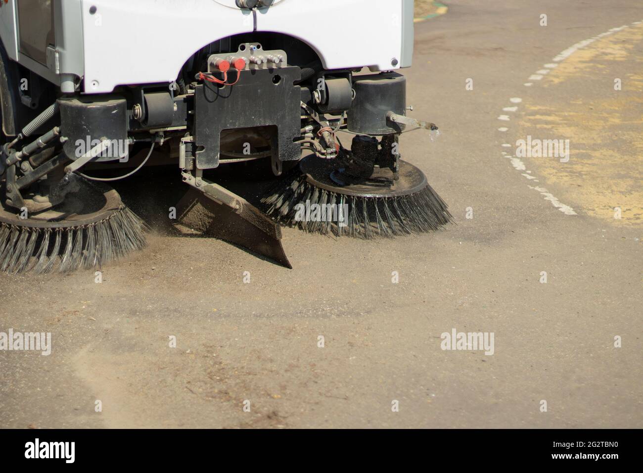 The sweeper is sweeping the asphalt. Cleaning the path with a cleaning ...