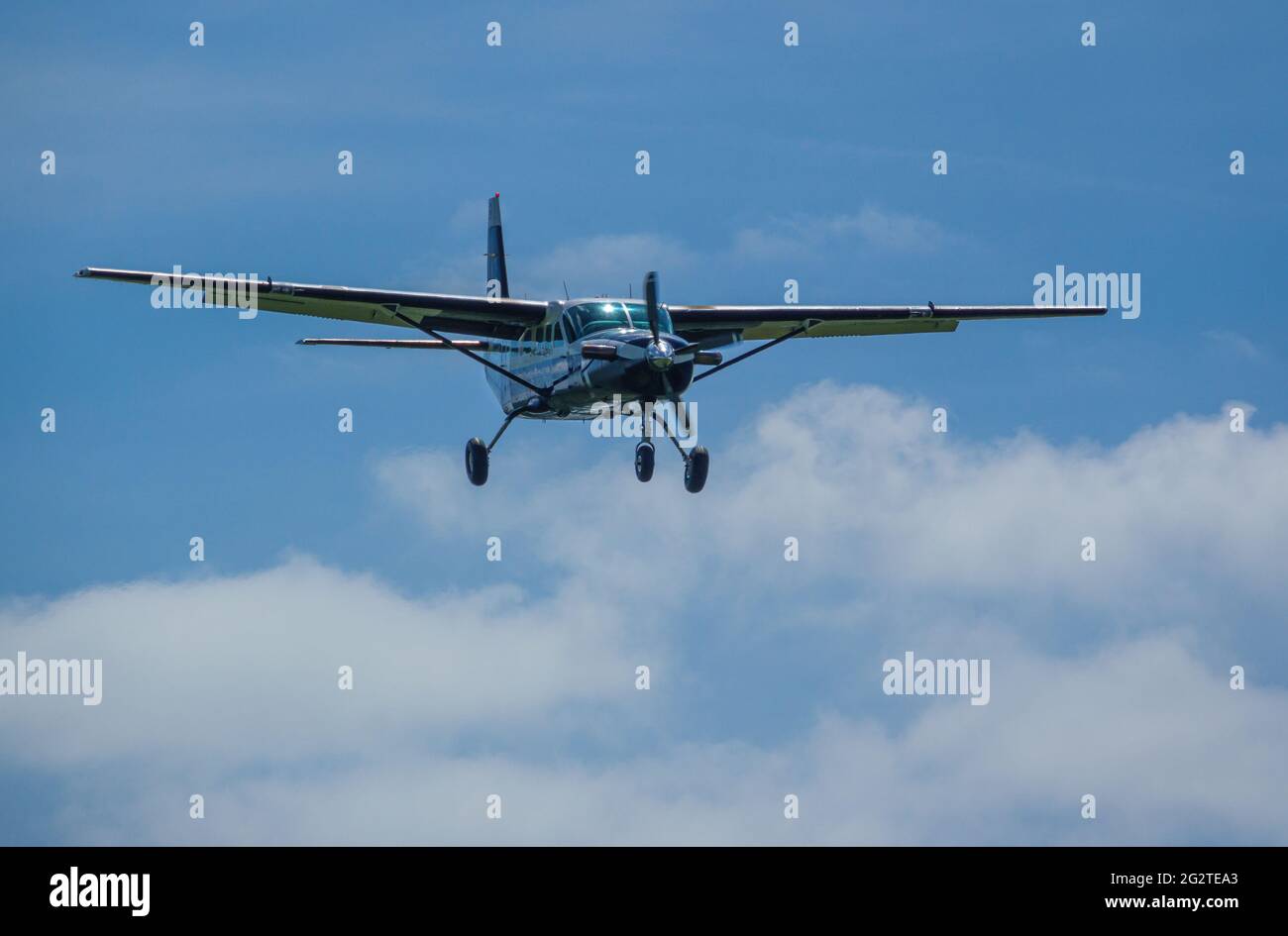 a cessna grand caravan 208B aircraft returns to land on a grass runway ...
