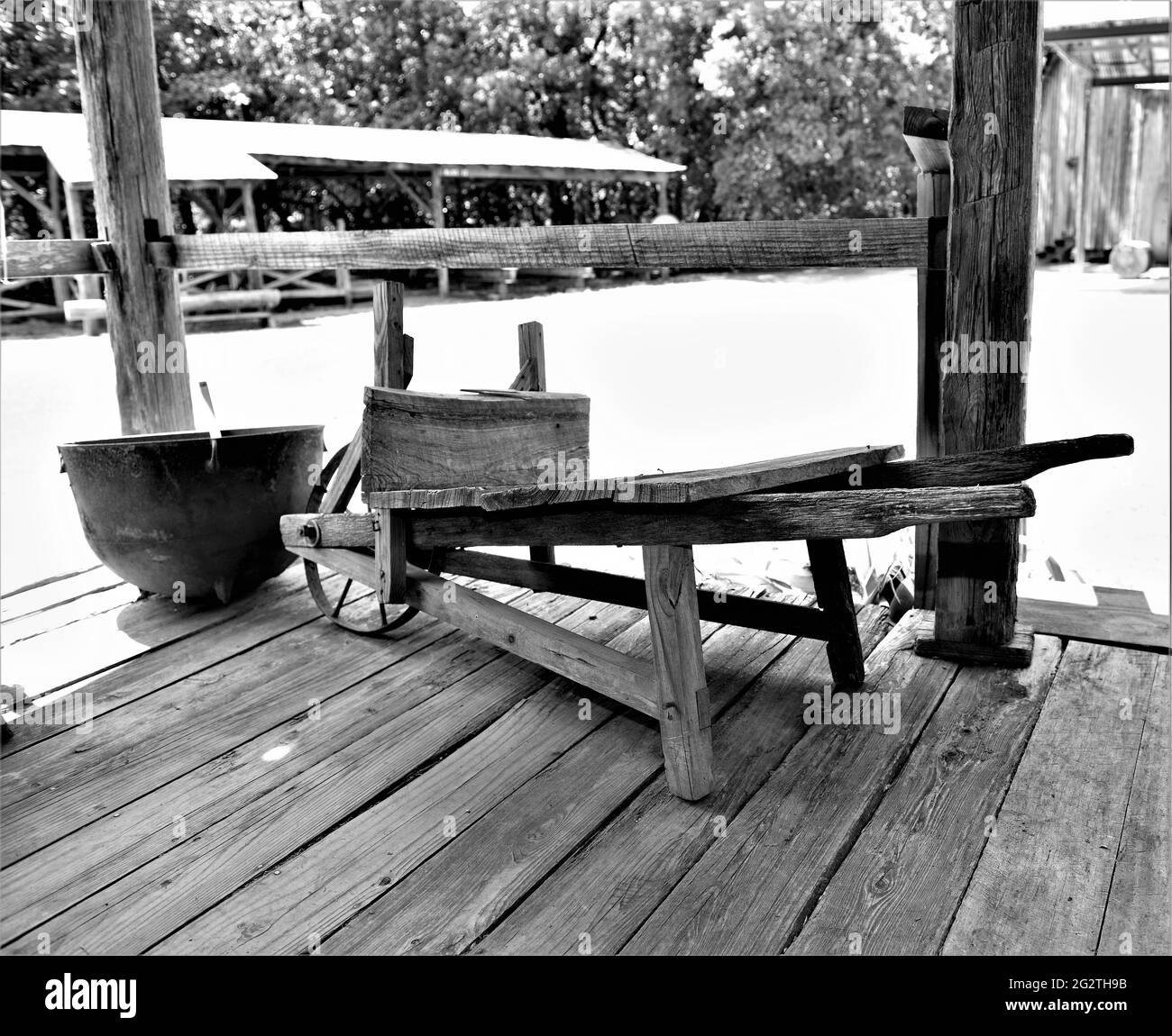 Wheel barrow and a cast iron pot Stock Photo - Alamy