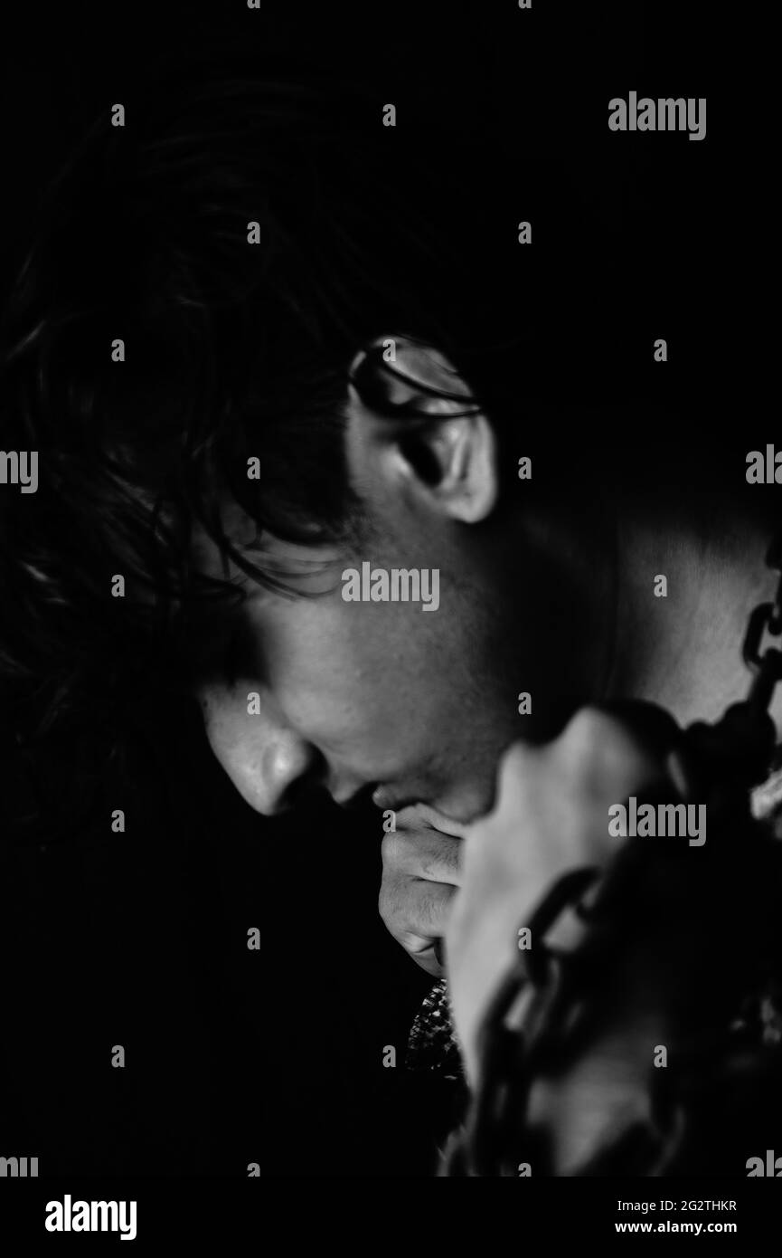 Grayscale shot of a handsome guy posing chained up Stock Photo - Alamy