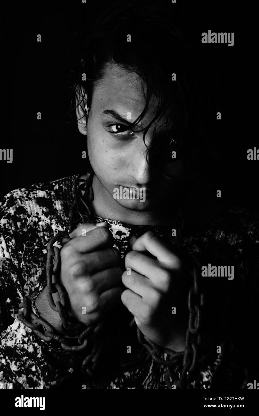 Grayscale shot of a handsome guy posing chained up Stock Photo - Alamy
