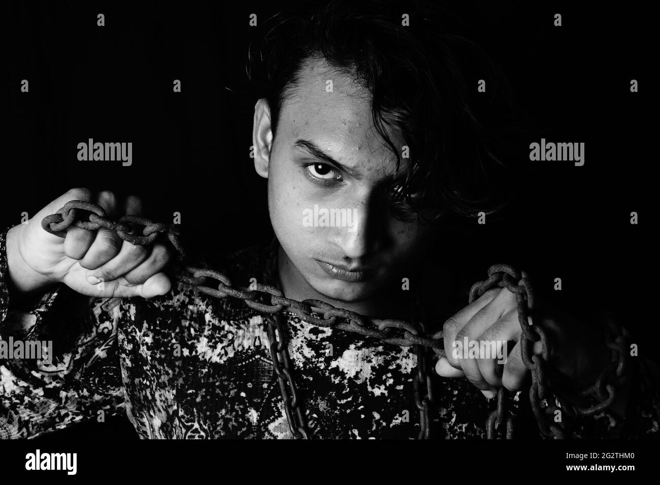 Grayscale shot of a handsome guy posing chained up Stock Photo - Alamy