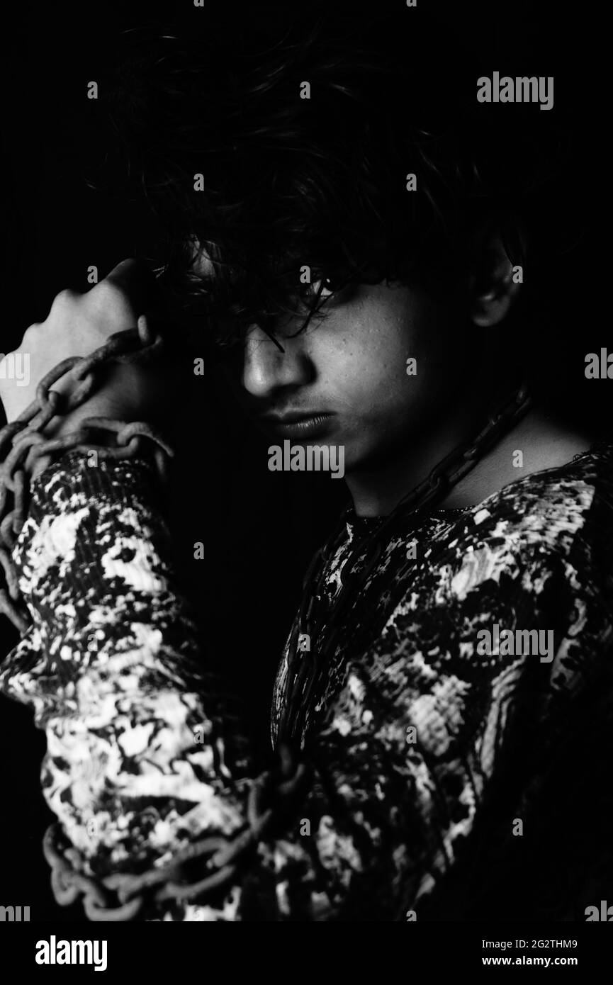 Grayscale shot of a handsome guy posing chained up Stock Photo - Alamy