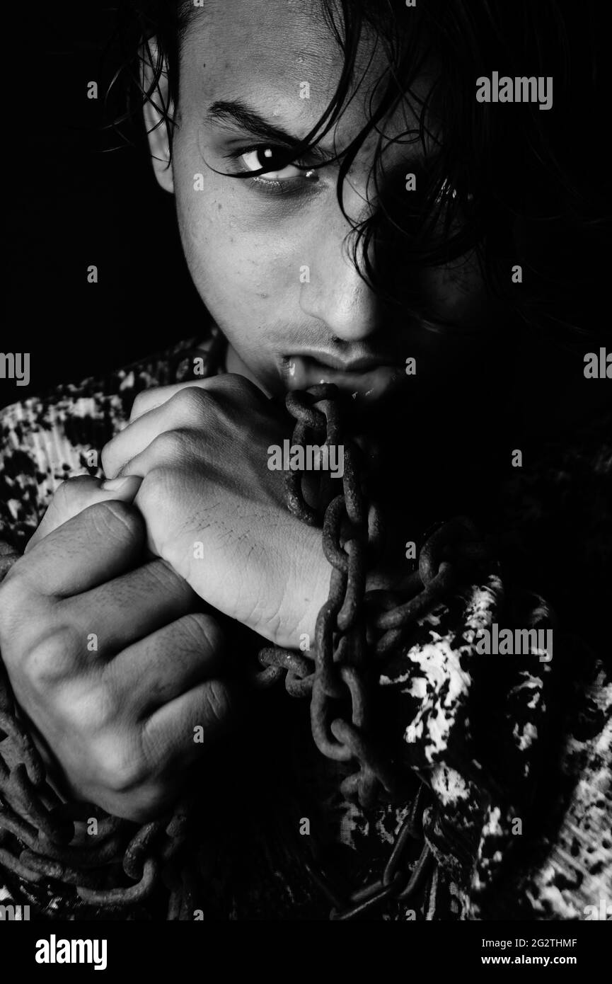 Grayscale shot of a handsome guy posing chained up Stock Photo - Alamy