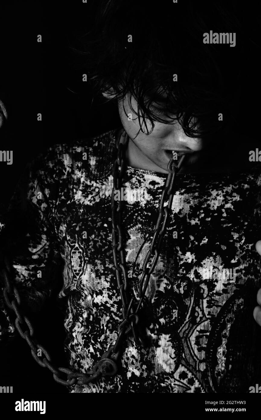 Grayscale shot of a handsome guy posing chained up Stock Photo - Alamy