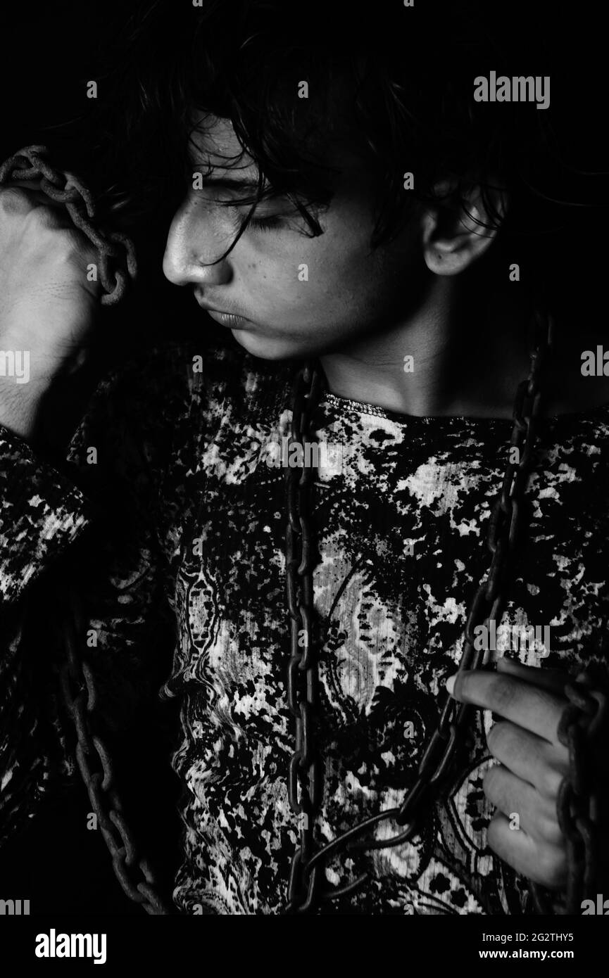 Grayscale shot of a handsome guy posing chained up Stock Photo - Alamy