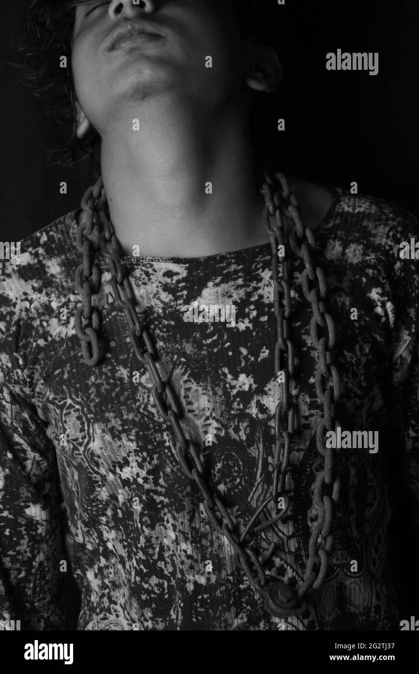 Grayscale shot of a handsome guy posing chained up Stock Photo - Alamy