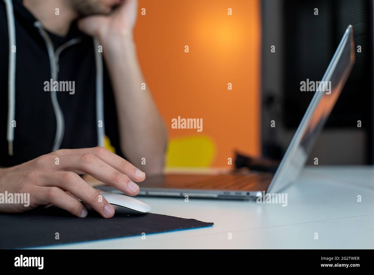 A closeup of a guy's hand clicking a wireless mouse while working on ...