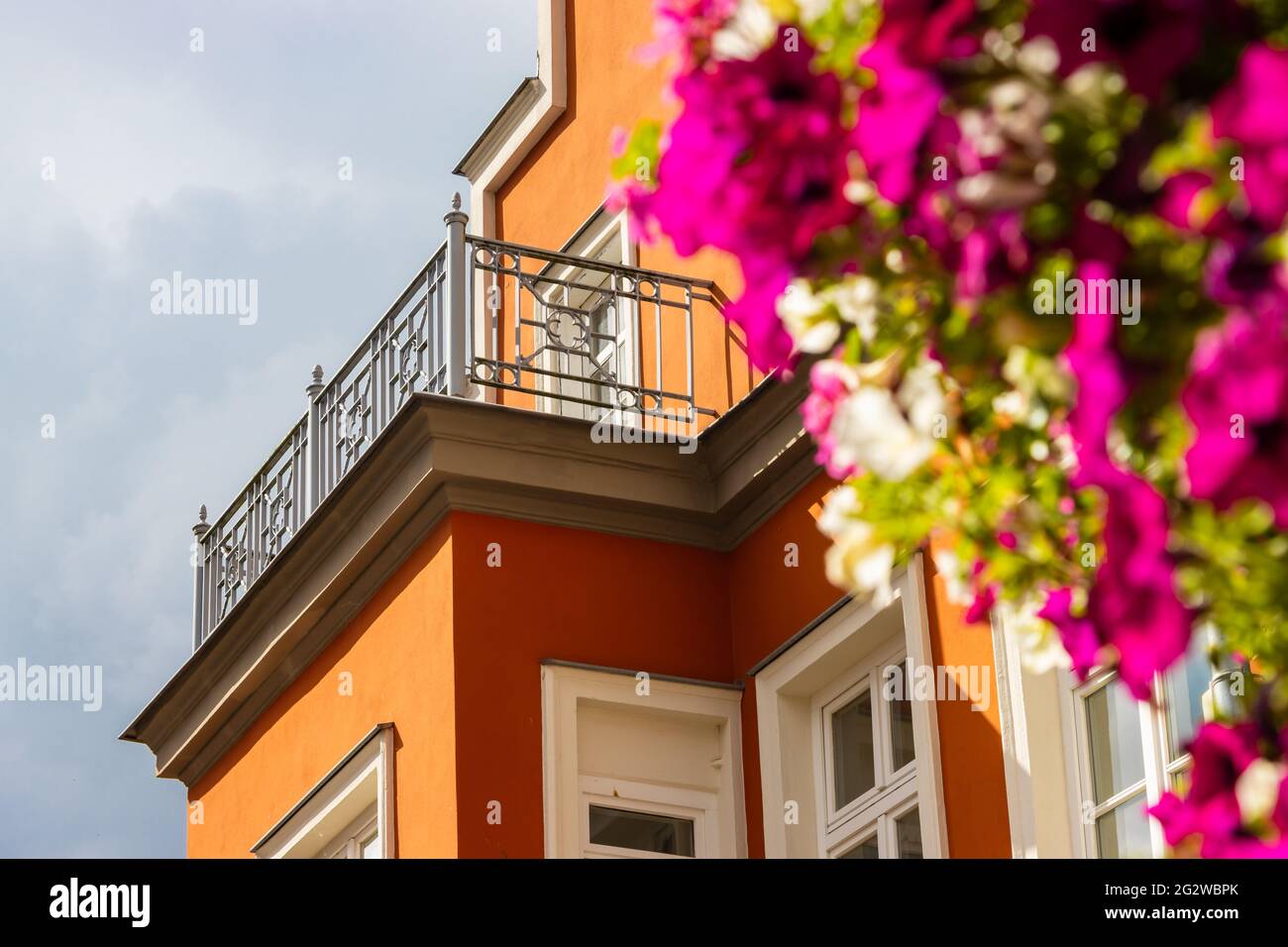 A modern orange building on a cloudy day in Greifswald, Germany with ...