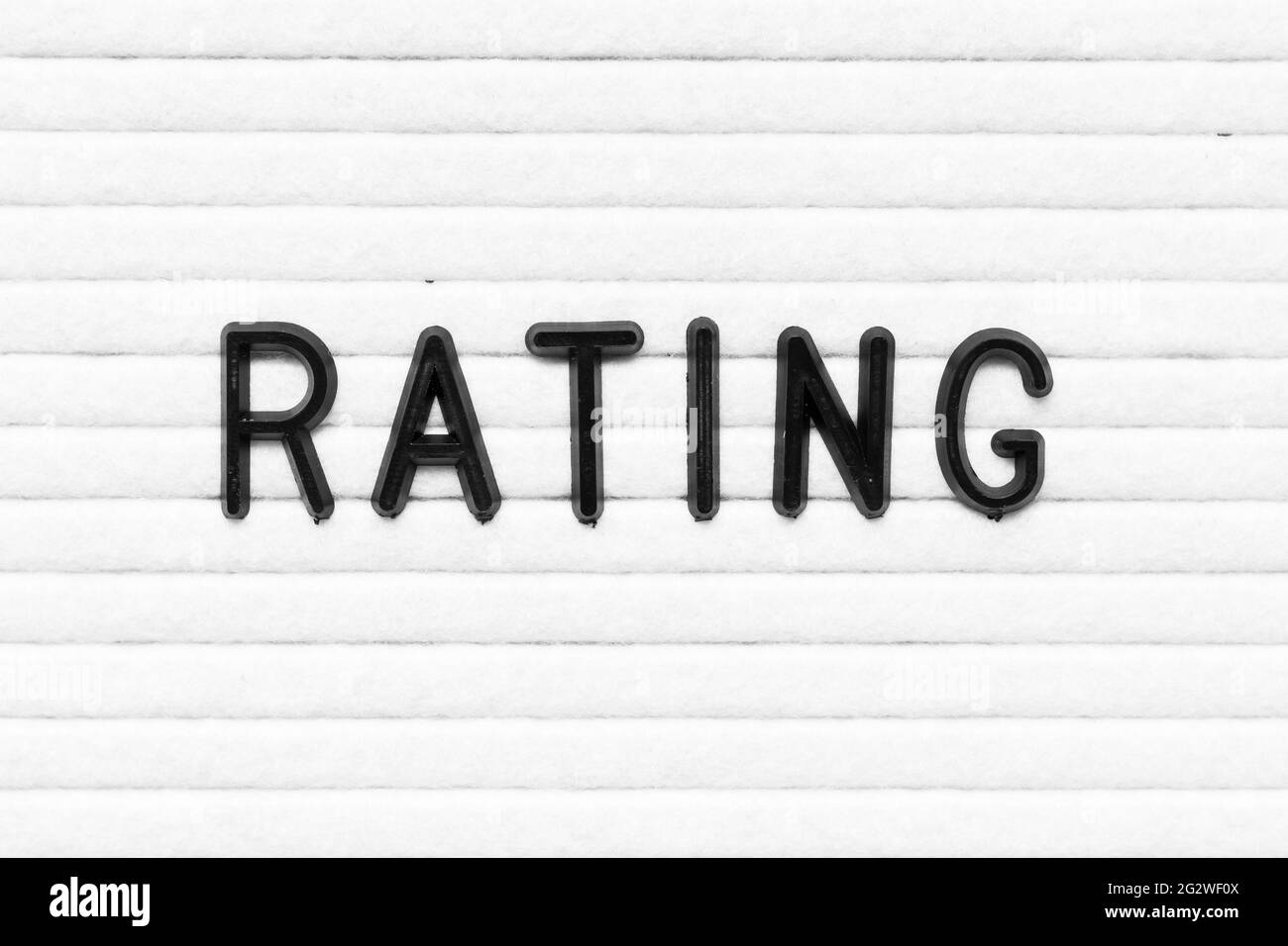 Black alphabet letter in word rating on white felt board background ...