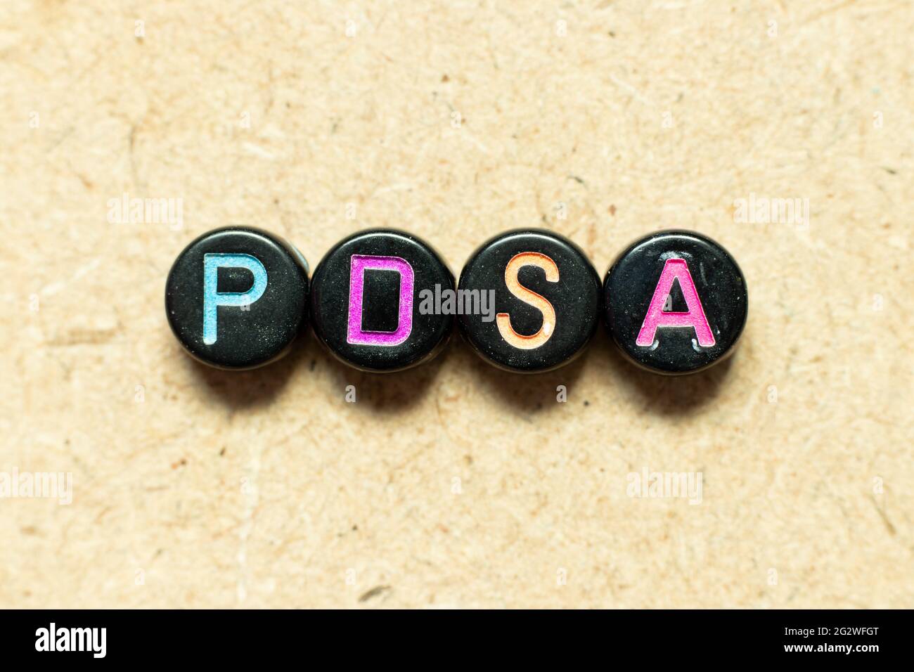 Black color round alphabet letter block in word PDSA (Abbreviation of ...