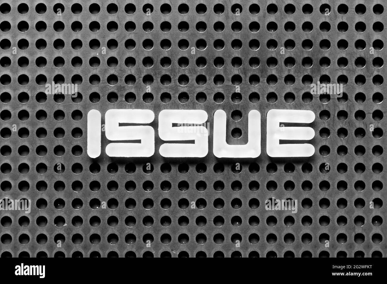 White alphabet letter in word issue on black pegboard background Stock ...