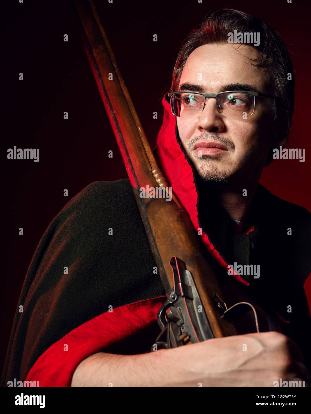 Portrait of soldier of past times in cape with his rifle slung over his ...