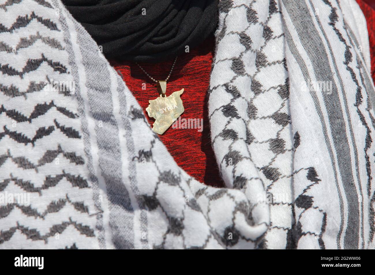 Woman wears the Palestinian Keffiyeh next to her necklace of Syria ...