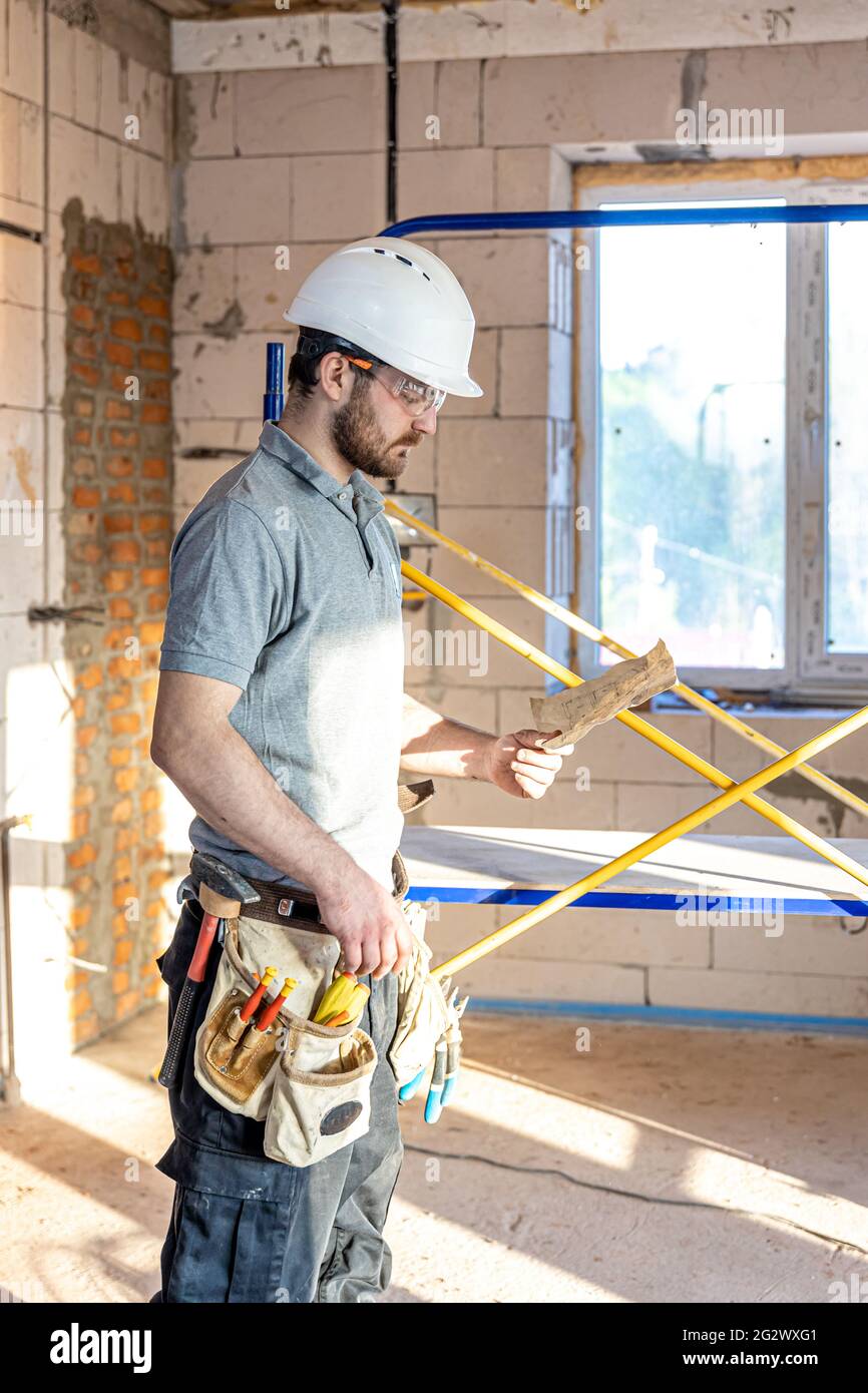 An electrician examines a construction drawing at a work site Stock ...