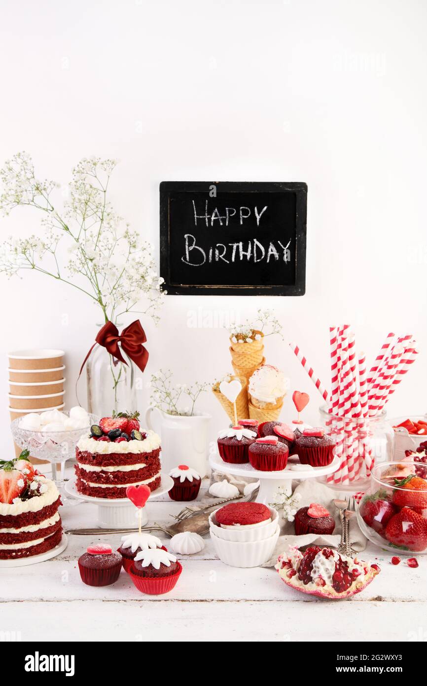 Delicious cake and cupcakes in red on white background. Table setting ...