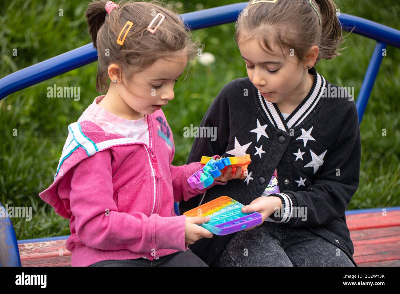 Little girls playing a new fidget toy popular with children helps them ...