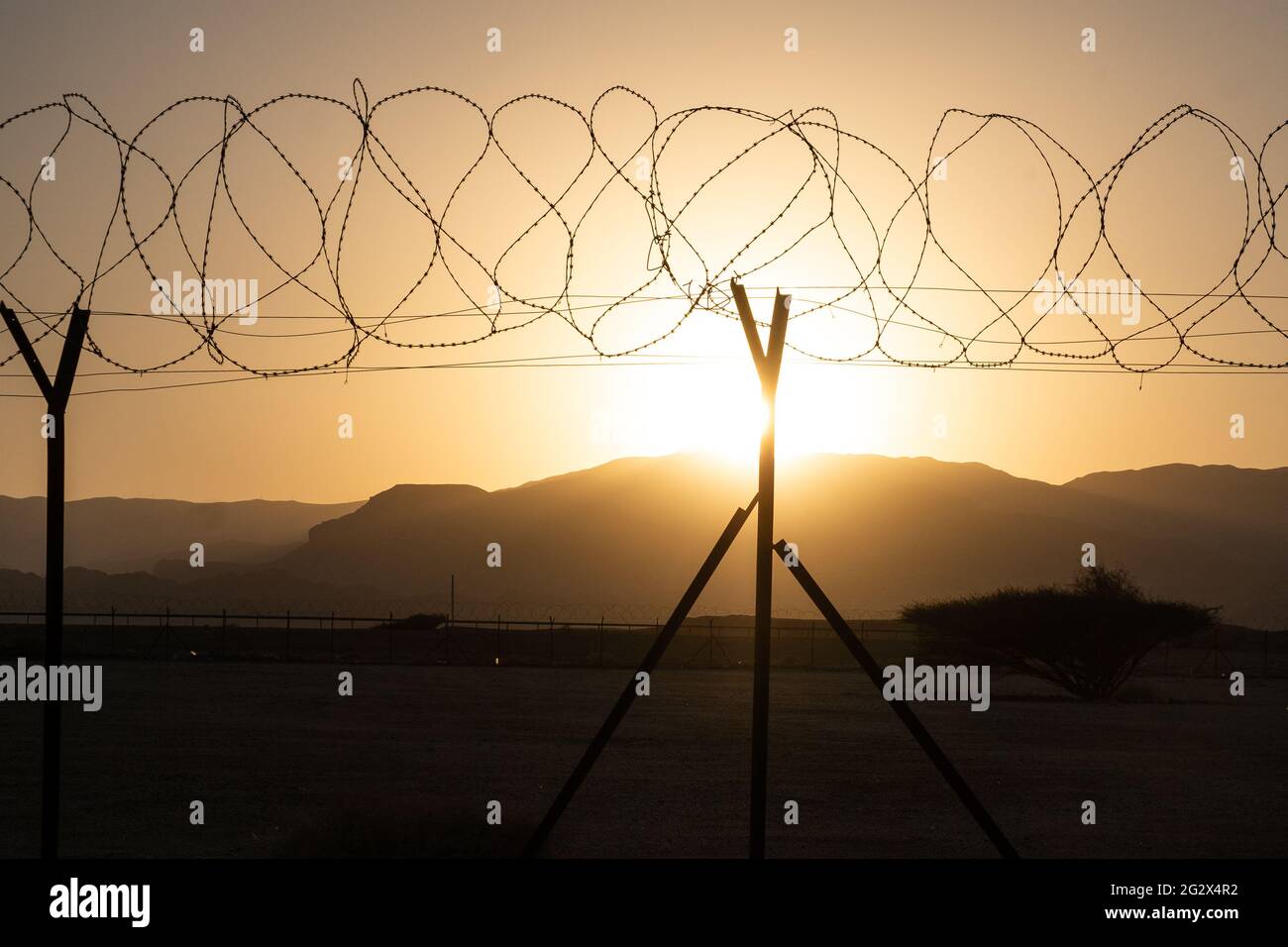Open Border Barbed wire fence at sunset Stock Photo - Alamy