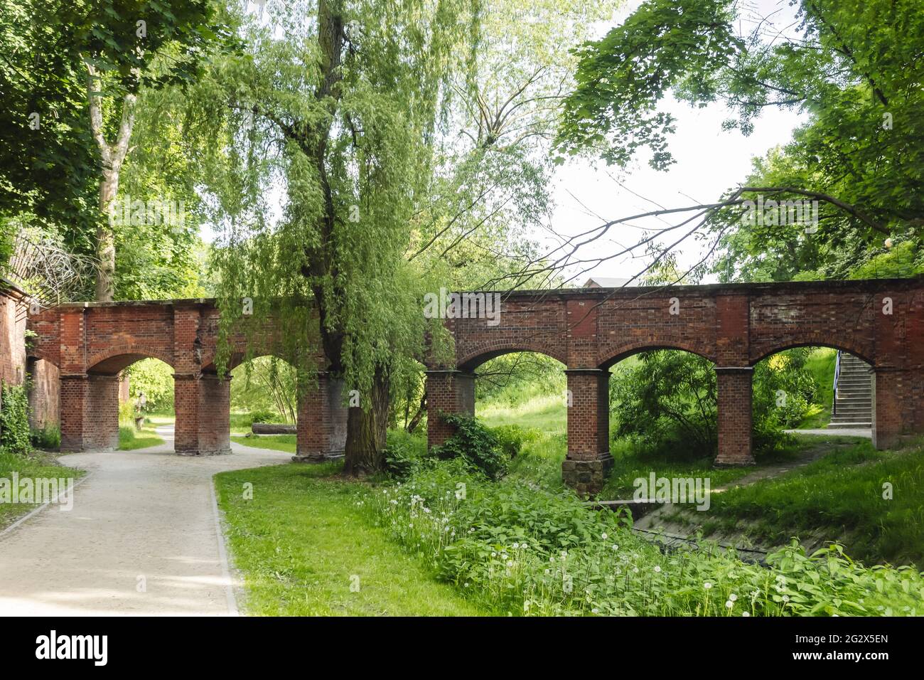 An arched red stone bridge in an old castle. View of the bridge with an ...