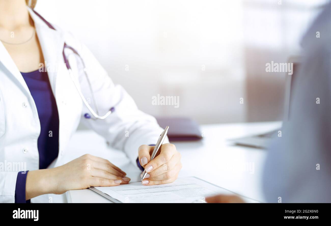 Unknown woman-doctor is prescribing some medication for her patient ...