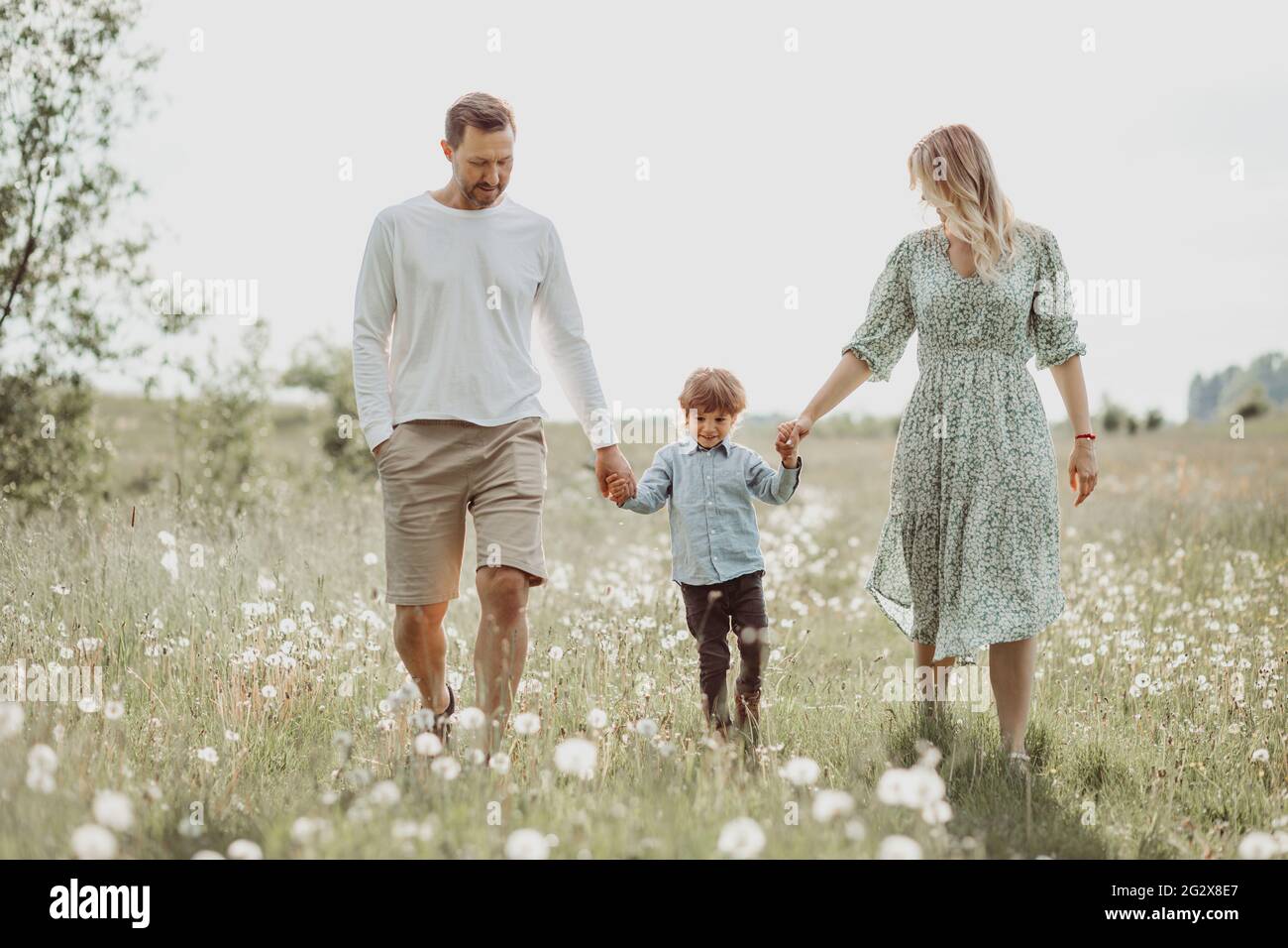 Young playful family with one child having fun in summer meadow, happy ...