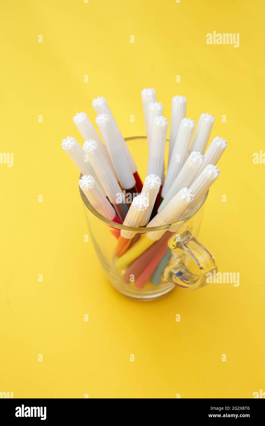 A set of colorful felt-tip pens on a cup on a yellow table Stock Photo ...