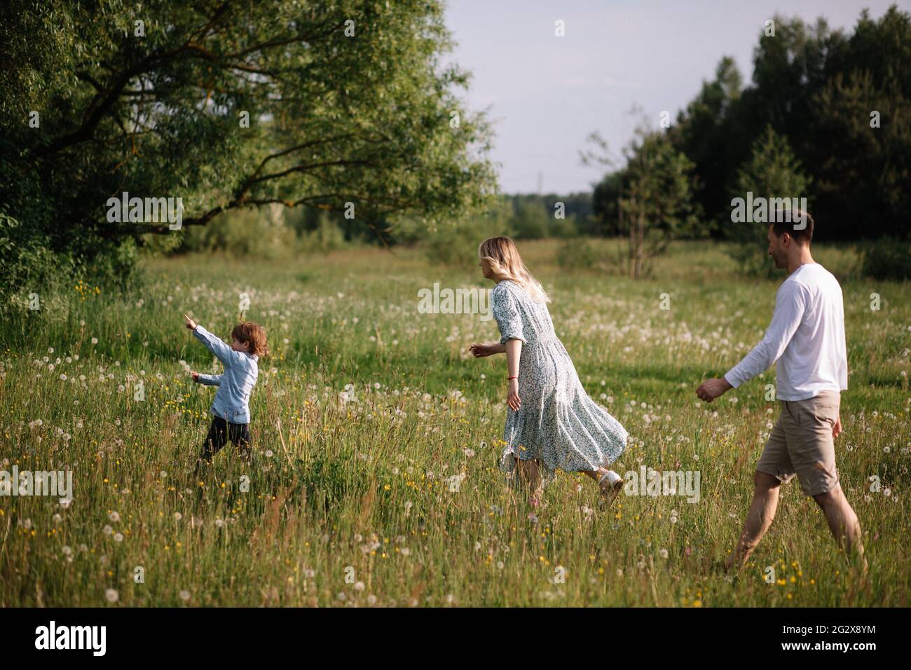 Mom and Dad run after baby across field, boy plays and runs away from ...