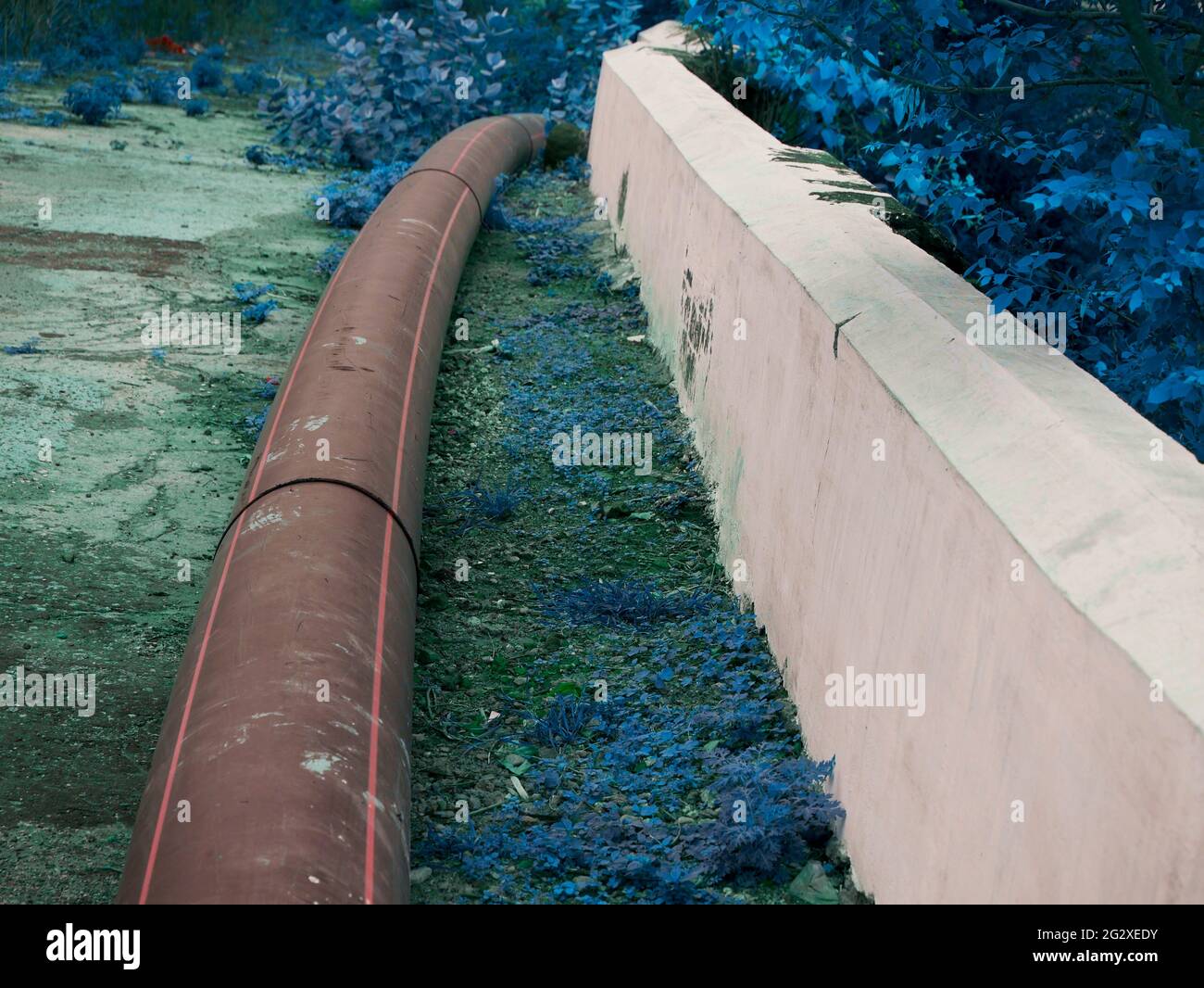 Water supply pipe closeup with side boundary wall around natural ...