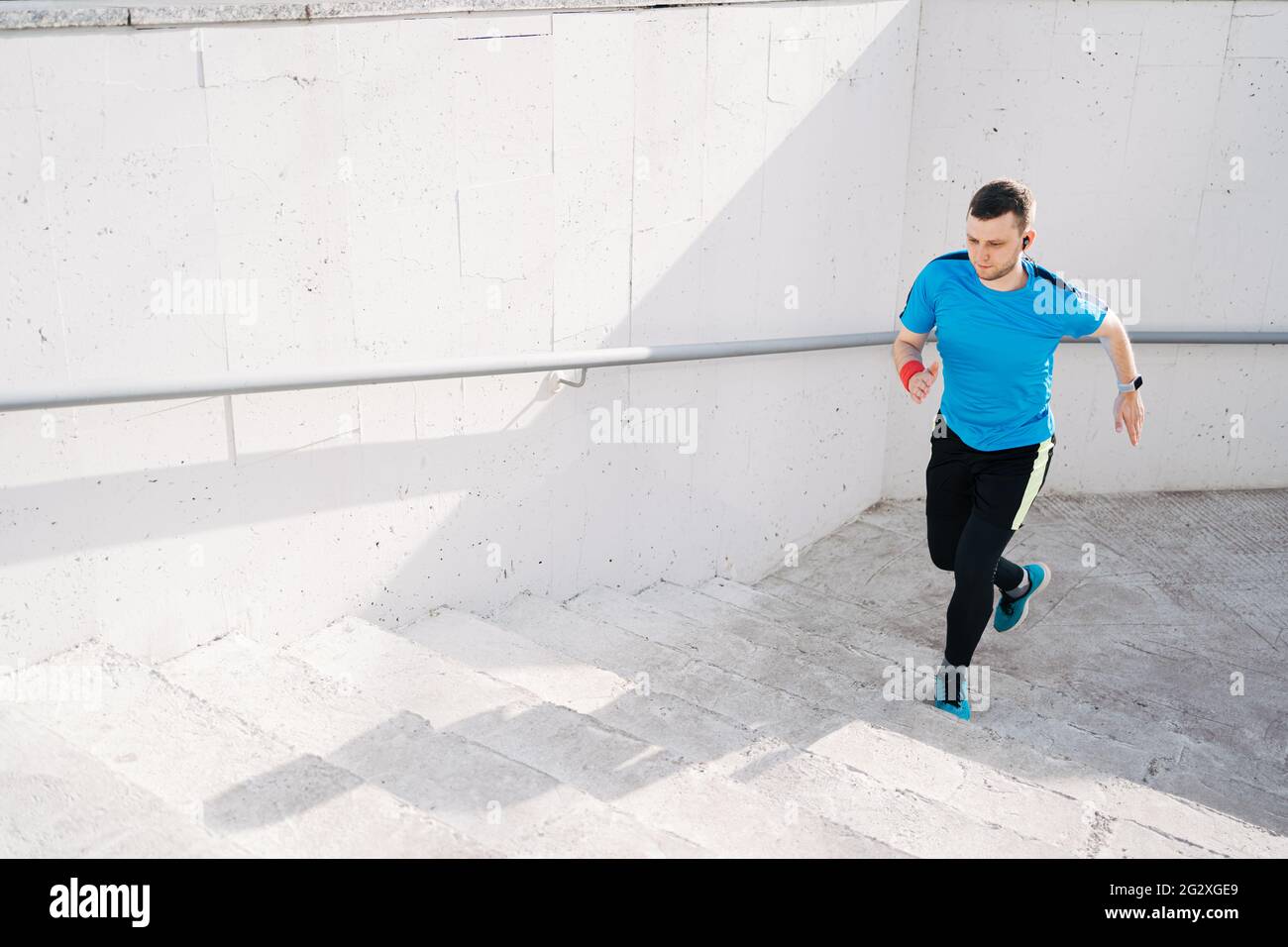 Young man running upstairs on city stairs. Fitness, sport, people ...
