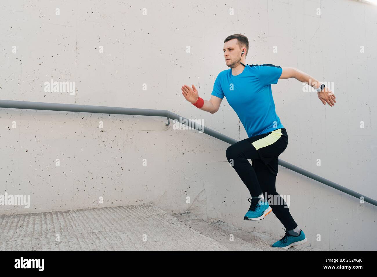 Young man running upstairs on city stairs. Fitness, sport, people ...