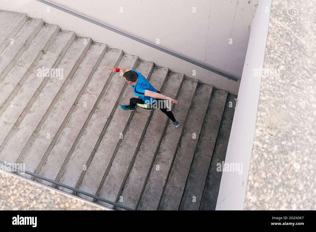 Young man running upstairs on city stairs. Fitness, sport, people ...