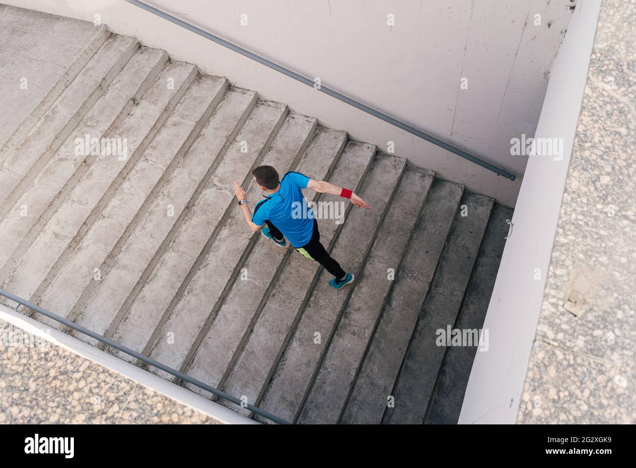 Young man running upstairs on city stairs. Fitness, sport, people ...