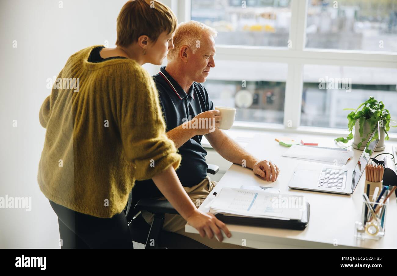 Creative professionals working together on laptop. Two business people ...