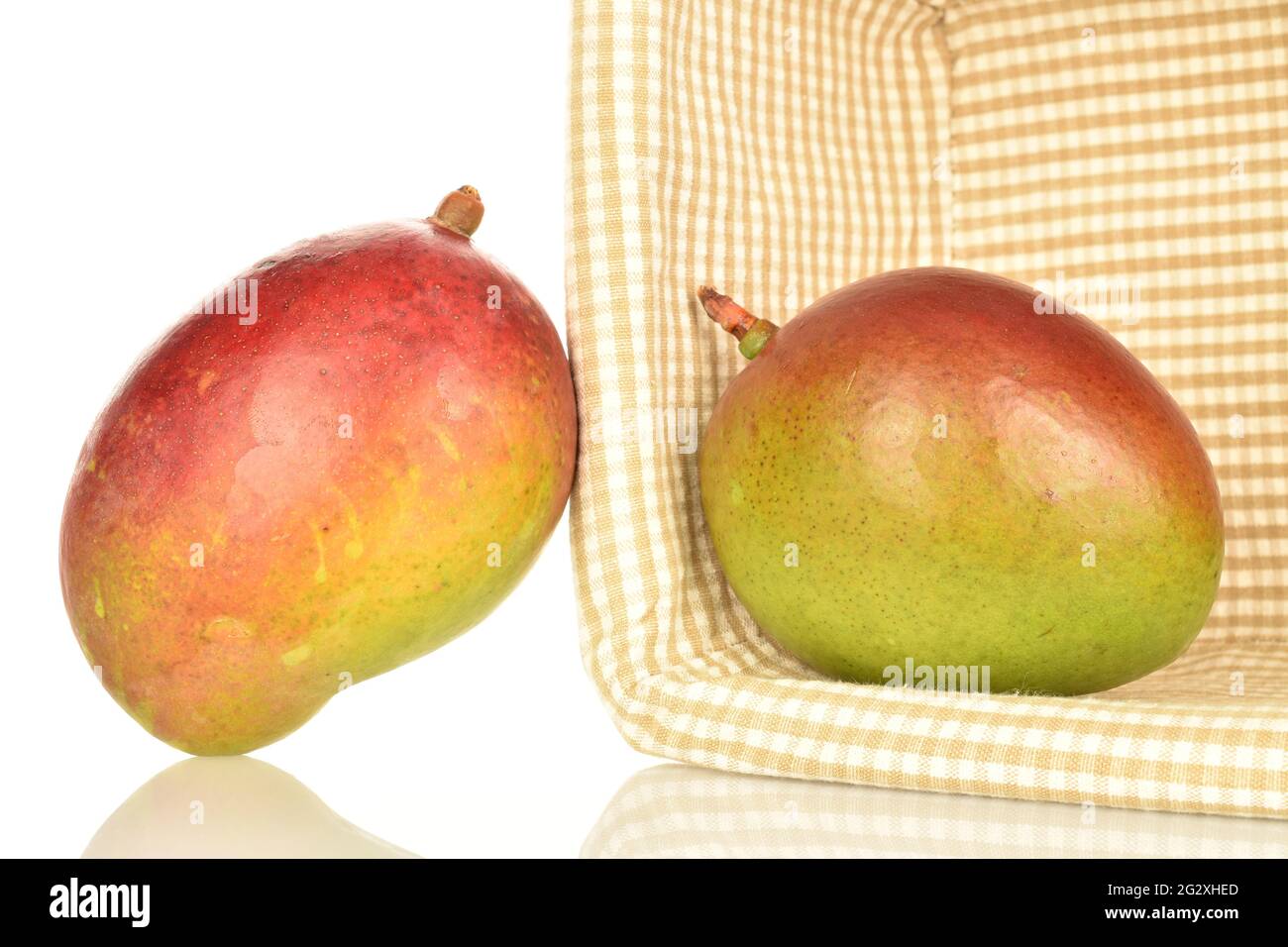 Two ripe mangoes with a basket, close-up, on a white background Stock ...