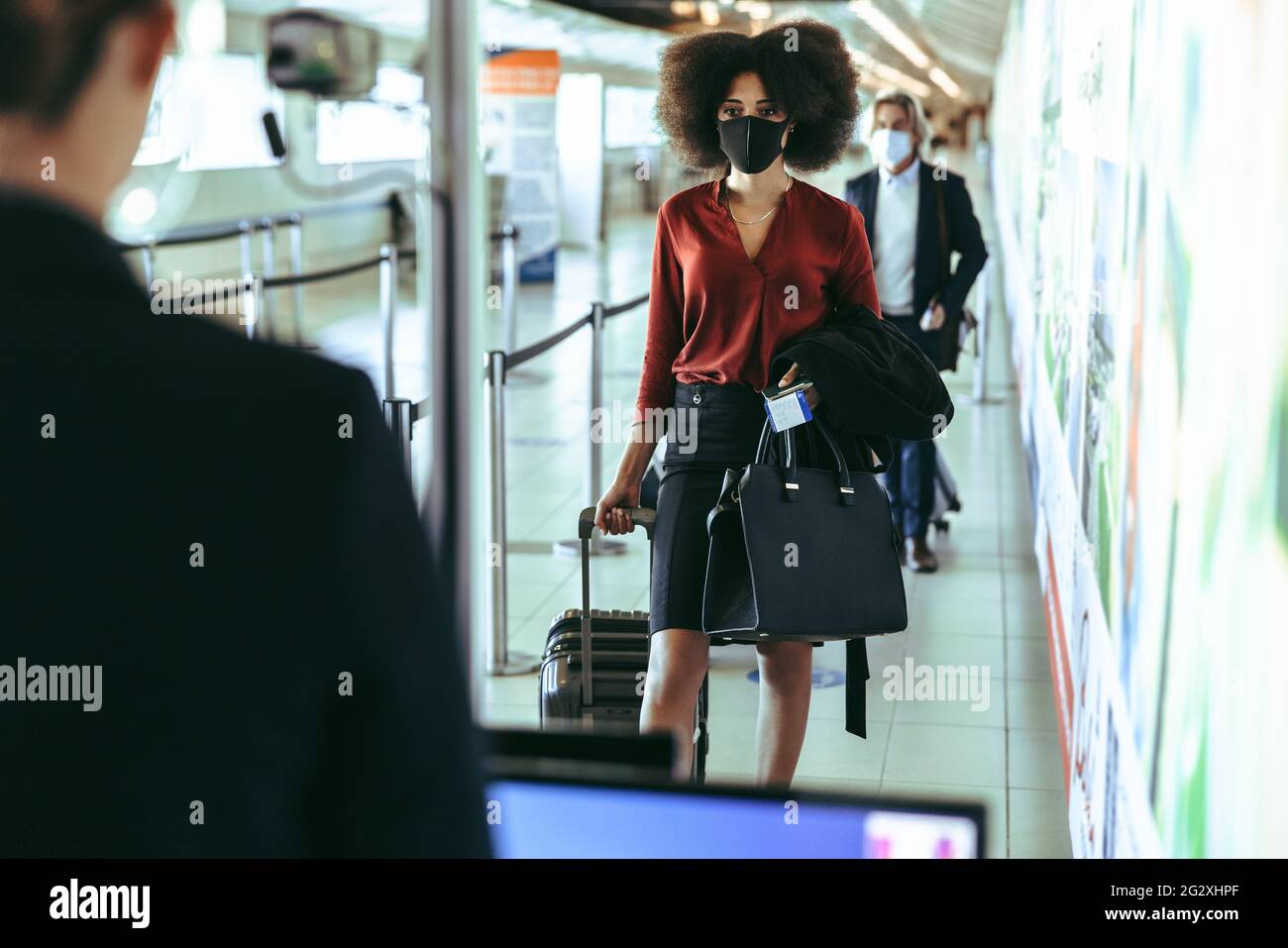 Woman traveler walking through thermal scanning checkpoint at airport ...