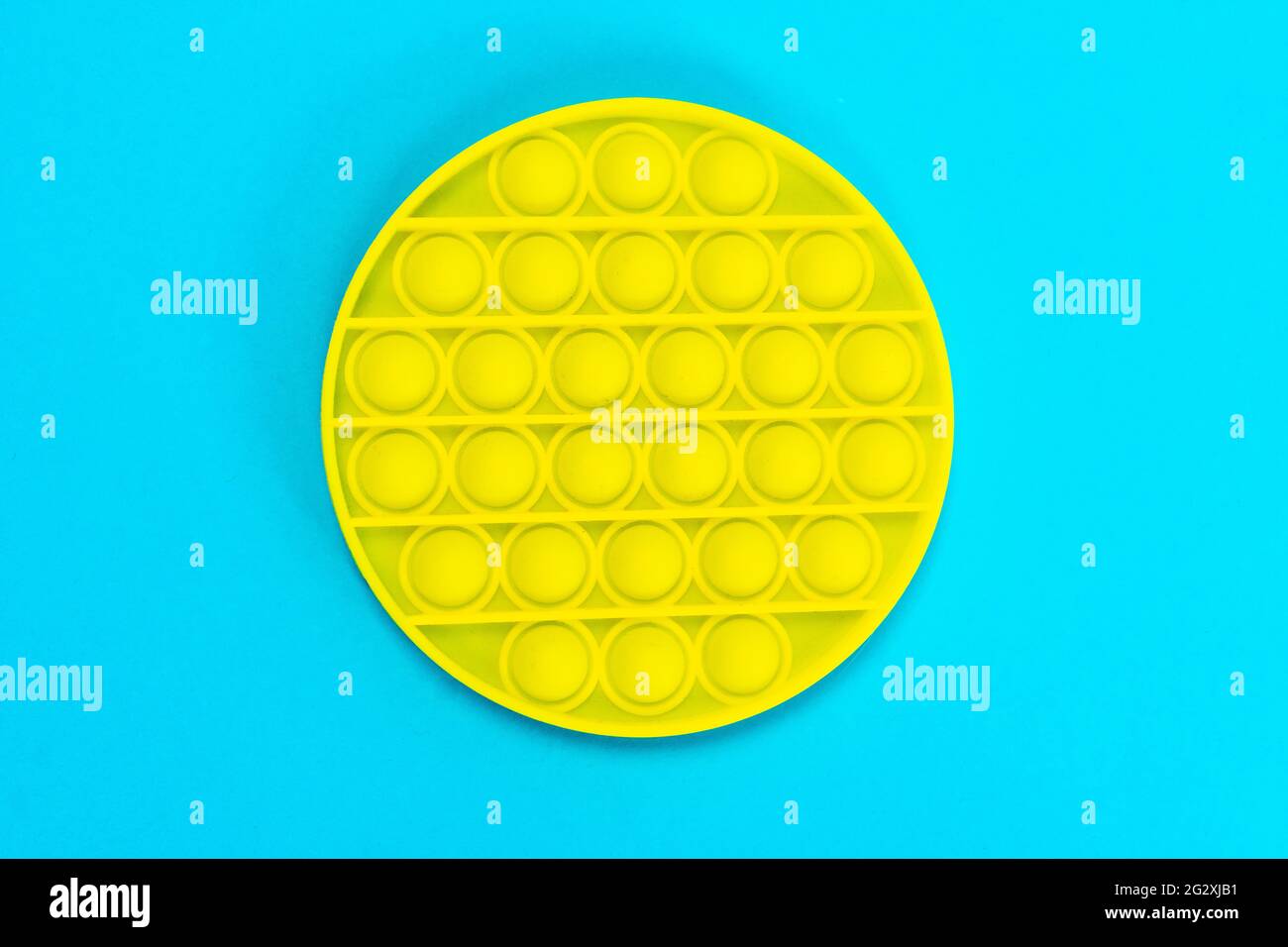 Round yellow popit on a blue background. Antistress toy trend of 2021 ...