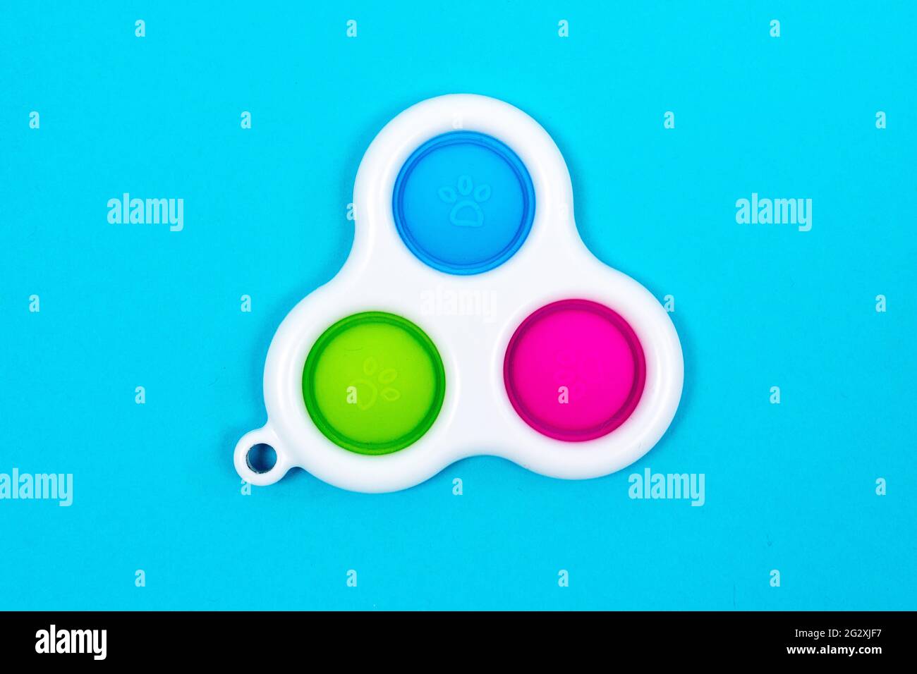 Multicolored simple dimple on a blue background. Antistress toy trend ...