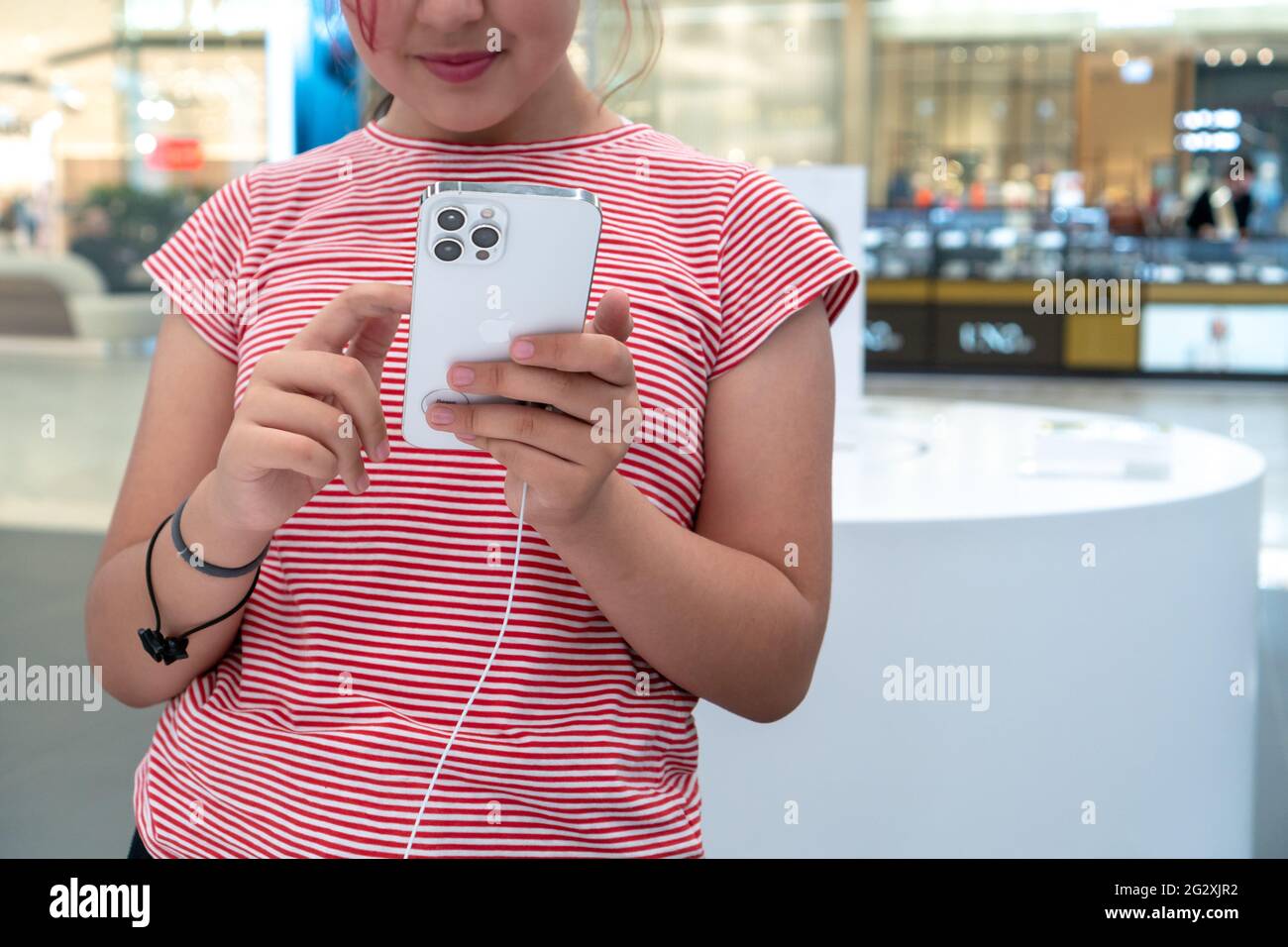 A charming little girl is holding in her arms Apple iPhone 12 Pro Max ...