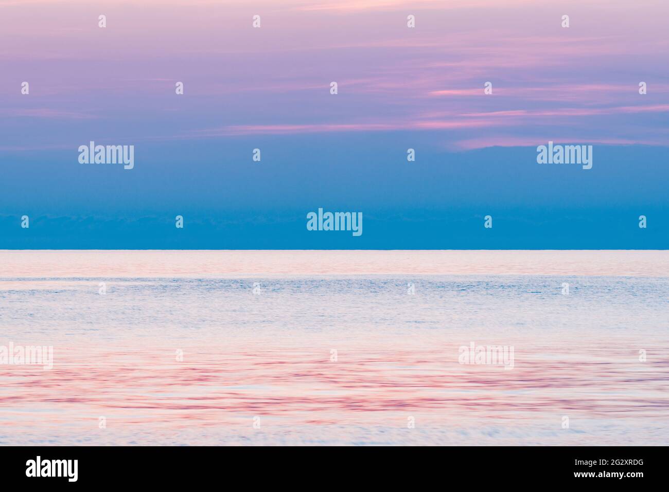 Pink sunset sky above the ocean surface Stock Photo - Alamy