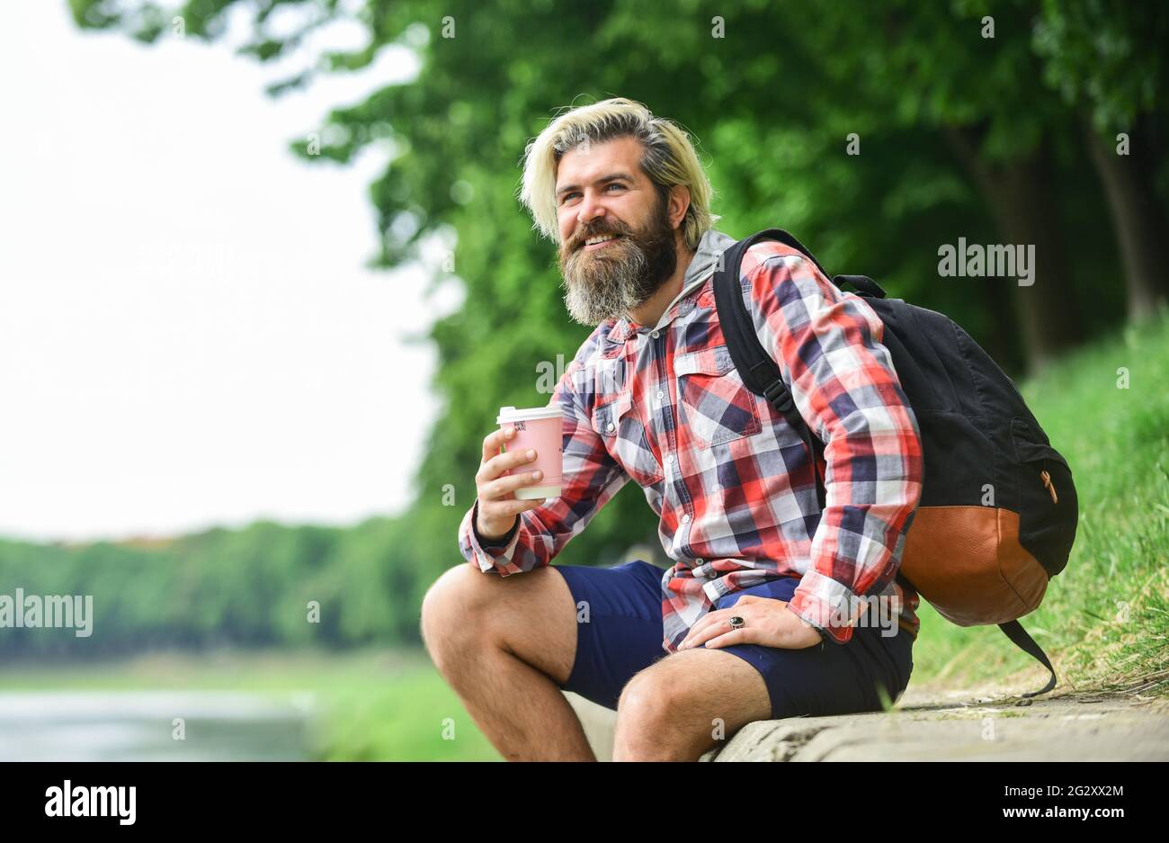 Handsome calm bearded man outdoors with a cup of coffee. Man drinking ...