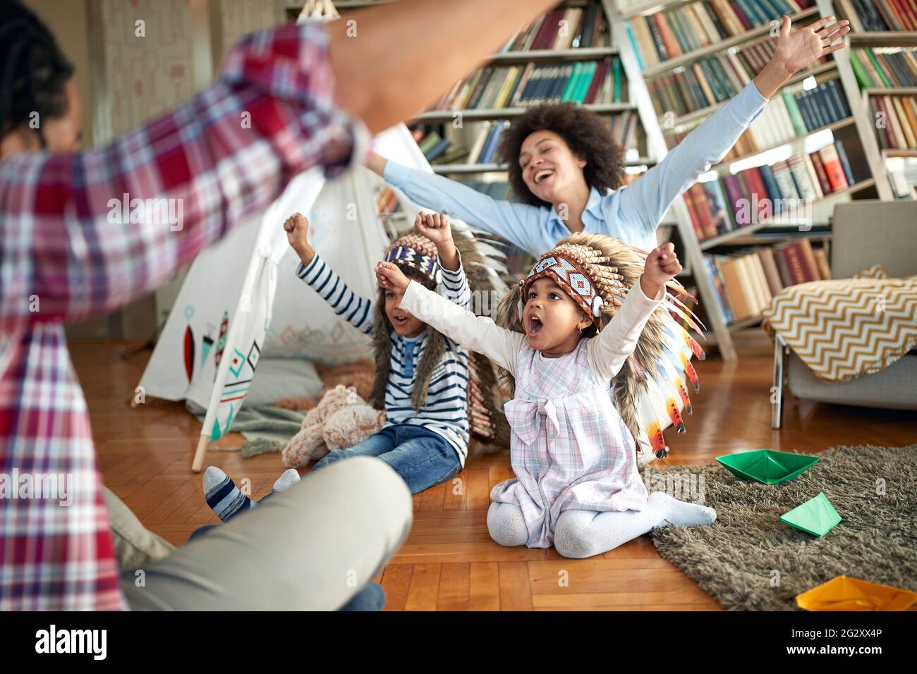 Excited kids with indian headdresses and their parents are yelling ...